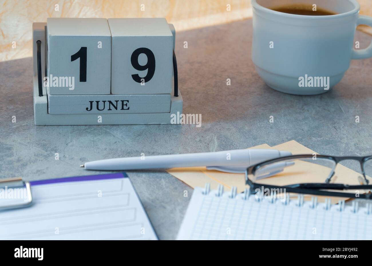 June 19, date on the calendar. Handmade wood cube with date month and ...