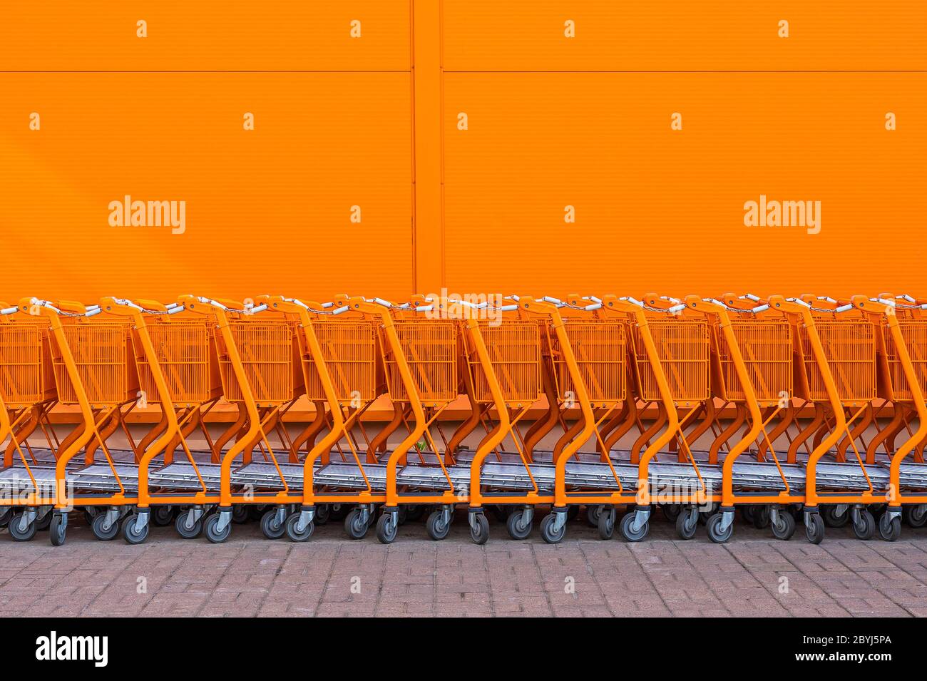 Orange shopping cart stacked by the entrance for new customers to use ...