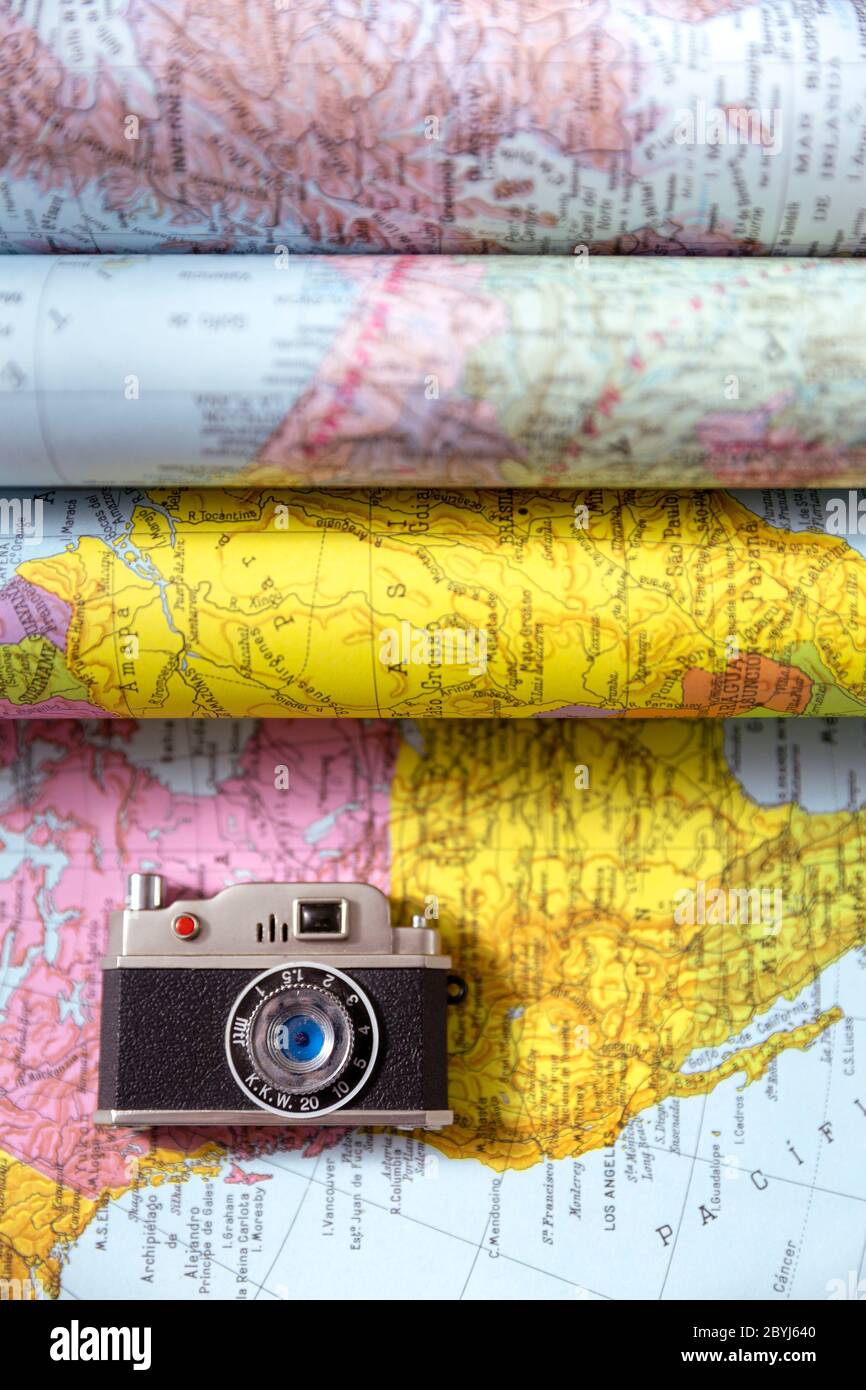 Toy photo camera miniature placed on world map. Top view. Travel ...