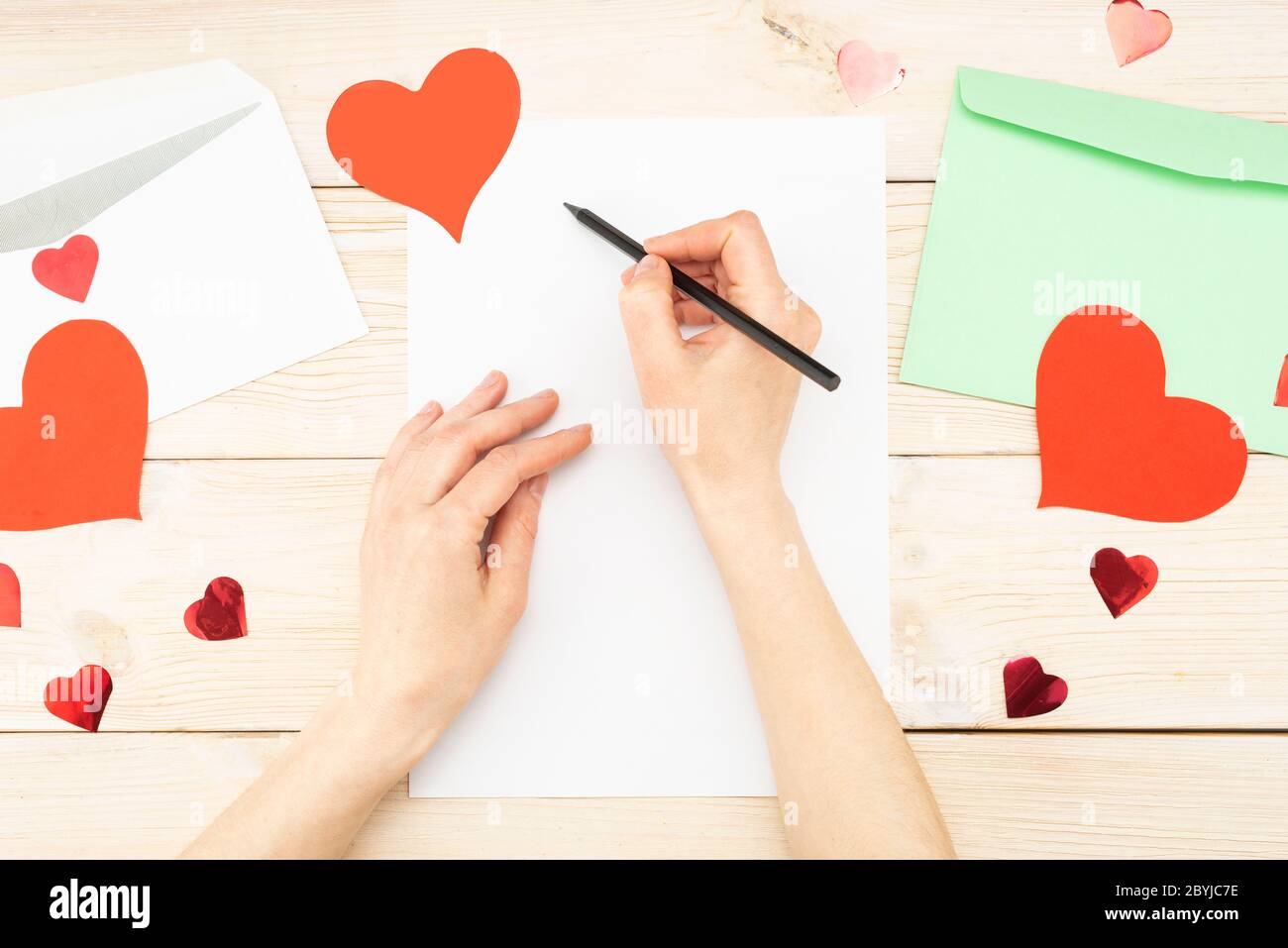 Girl's hand writes a love letter. Valentine's Day. Handmade greeting ...