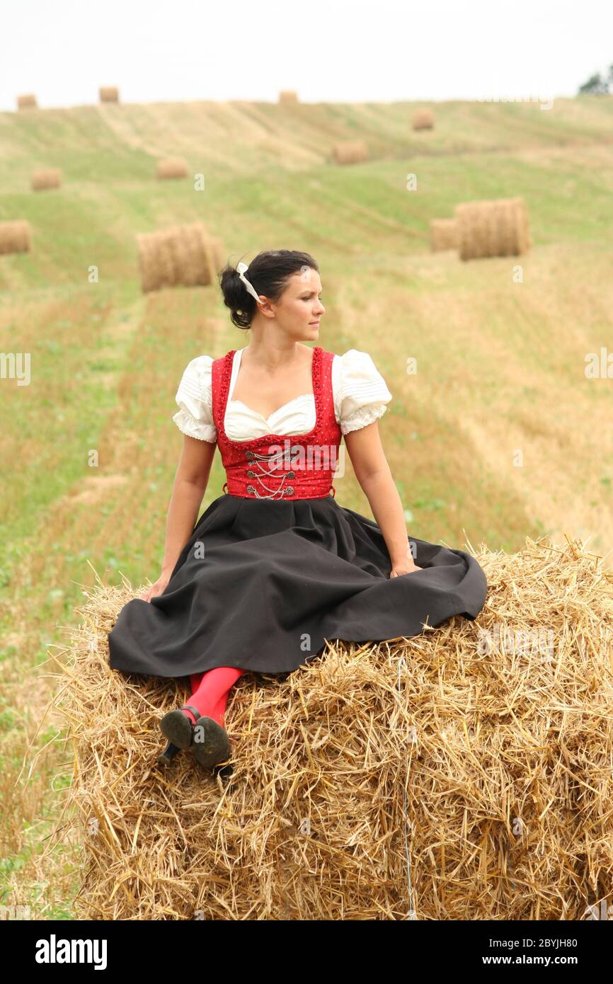 Female Girl sitting on the harvest countryside Stock Photo - Alamy