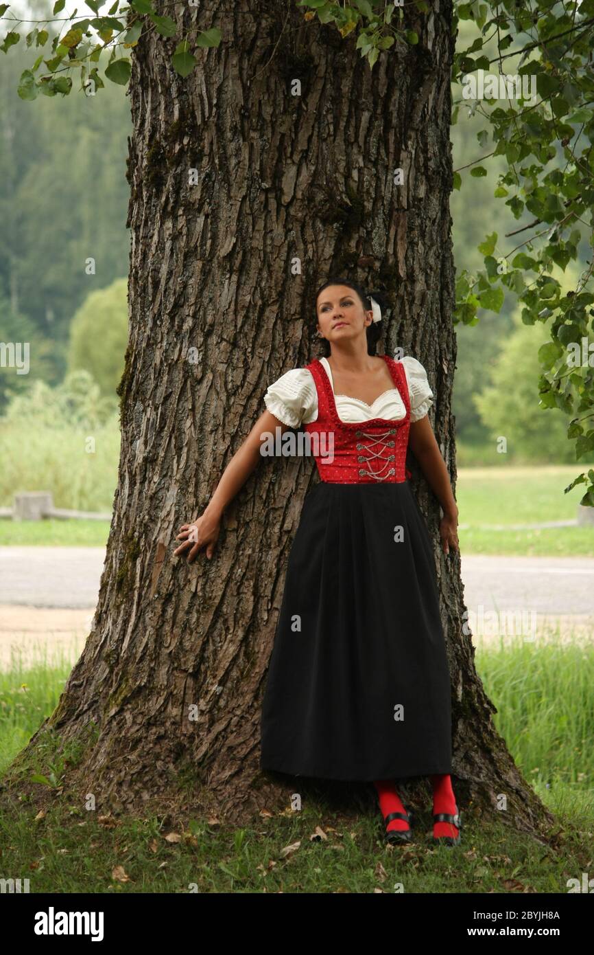 Female in Dirndl with Tree hug countryside Stock Photo - Alamy