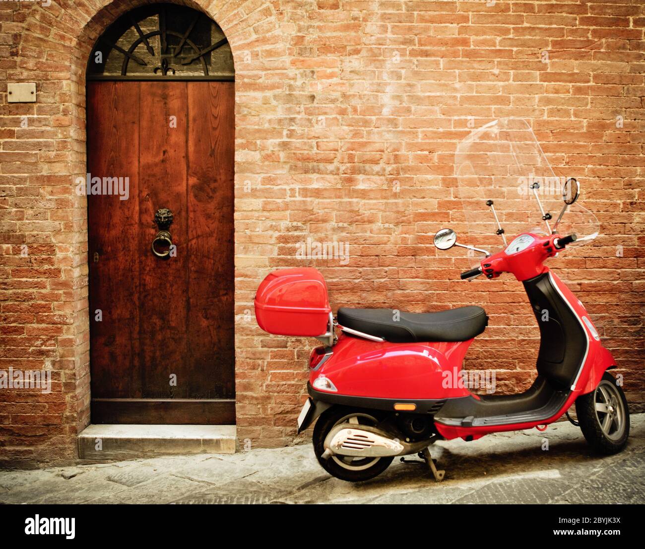 Vintage image of red scooter on the street Stock Photo - Alamy