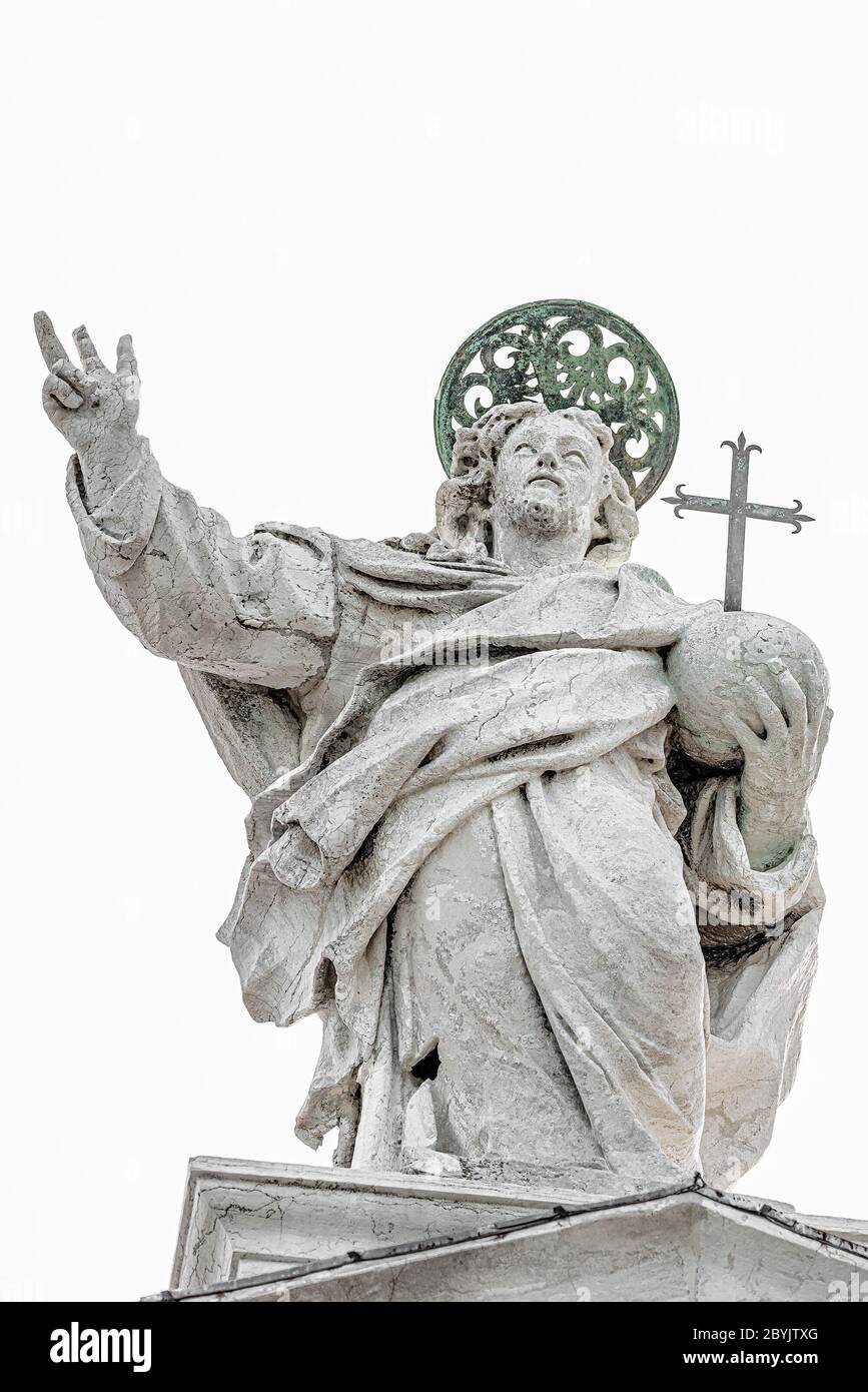 Holly priest with cross and nimbus at the roof of Church of San Giorgio ...