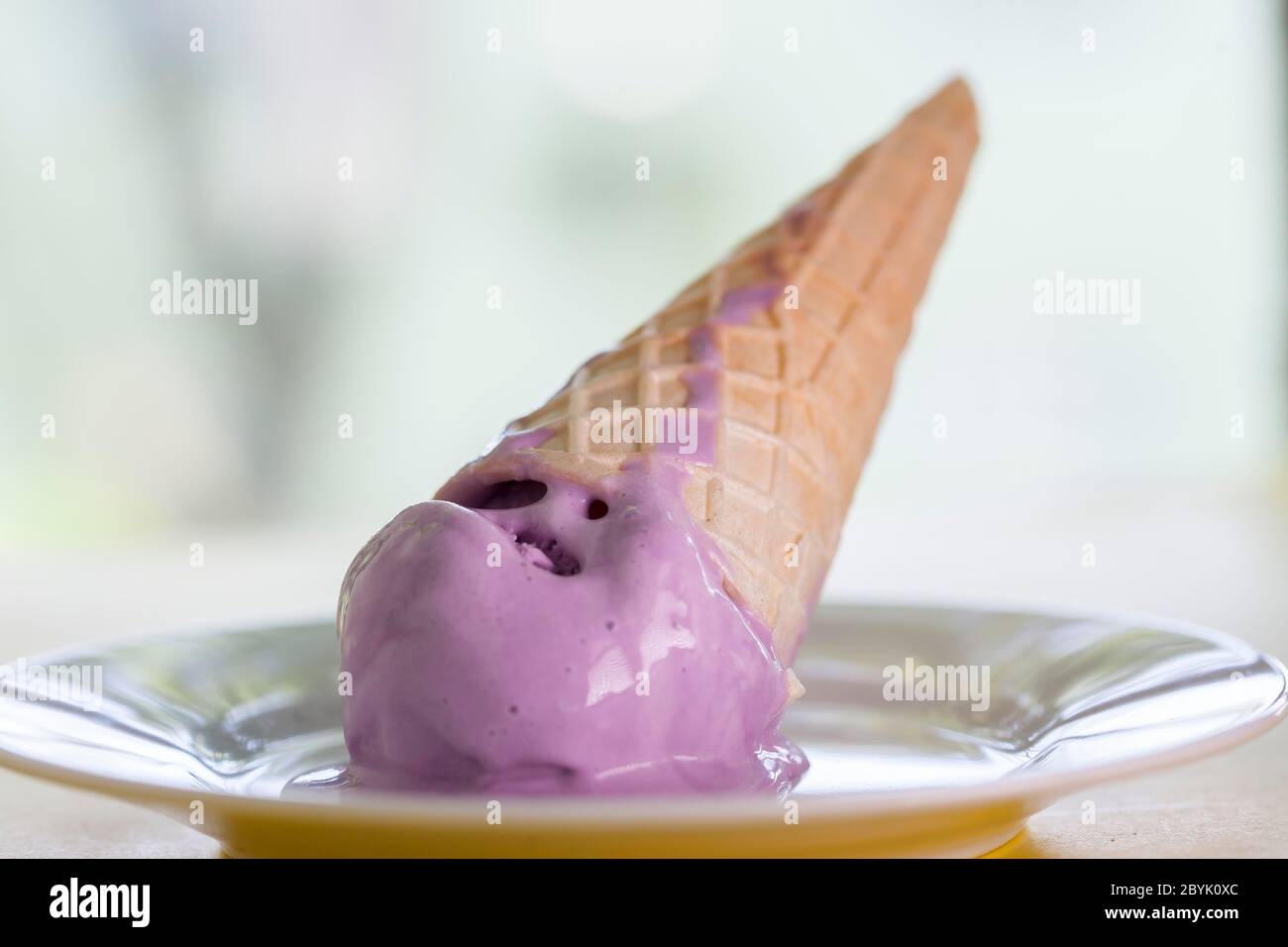 Melting purple ice cream on white plate Stock Photo - Alamy