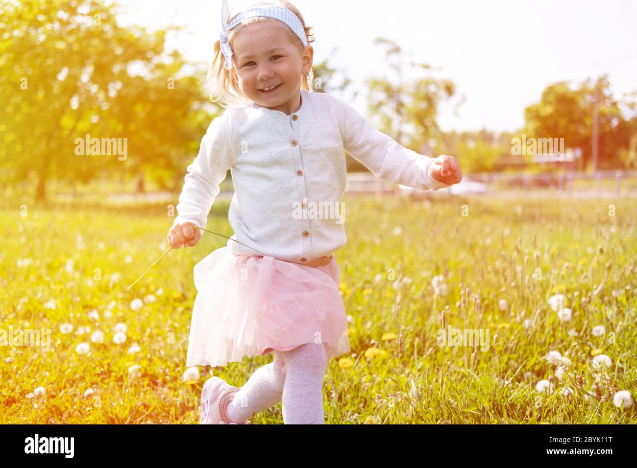 Cute little baby girl running in green park at sunset summer. Happy ...