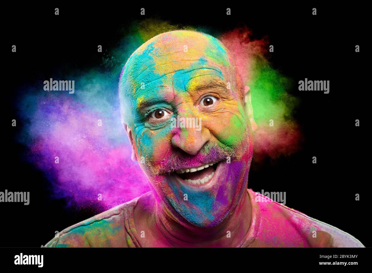Portrait of bald cheerful man with colorful face. Festival of colors ...