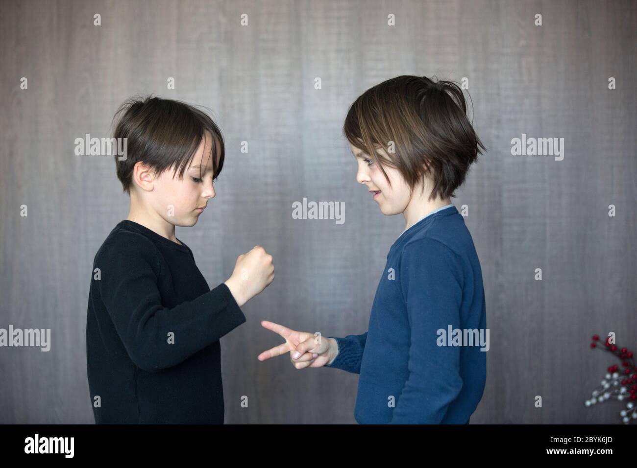 Two children, boy brothers, playing rock scissors paper game in garden ...