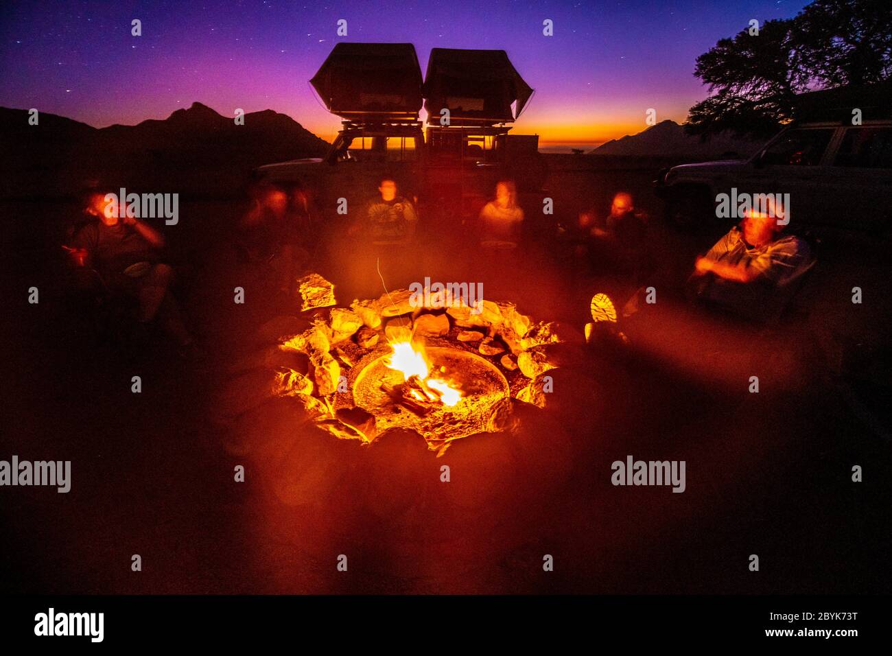 Everyone gathering around the campfire for a hot meal and some ...