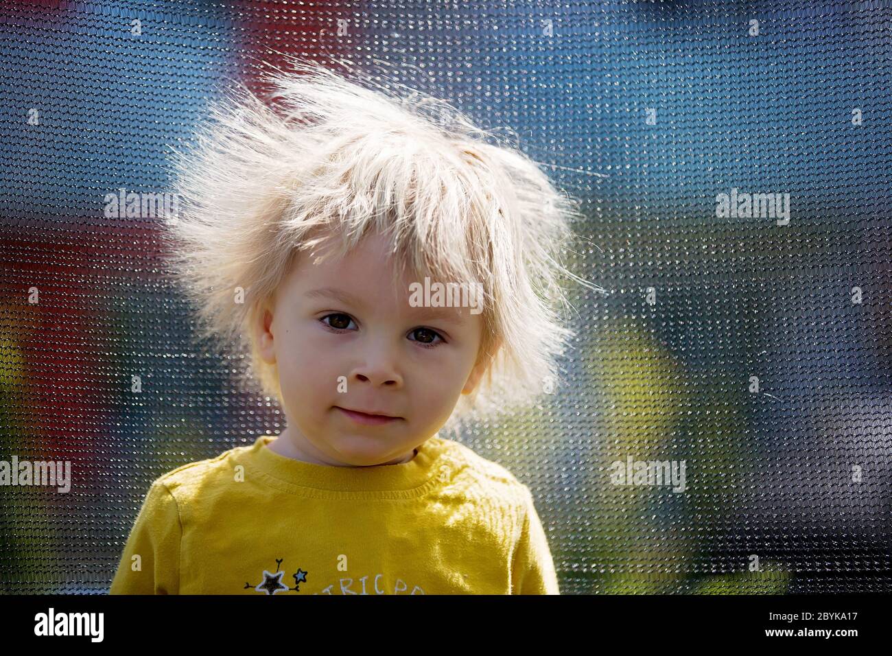 Cute little boy with static electricy hair, having his funny portrait ...