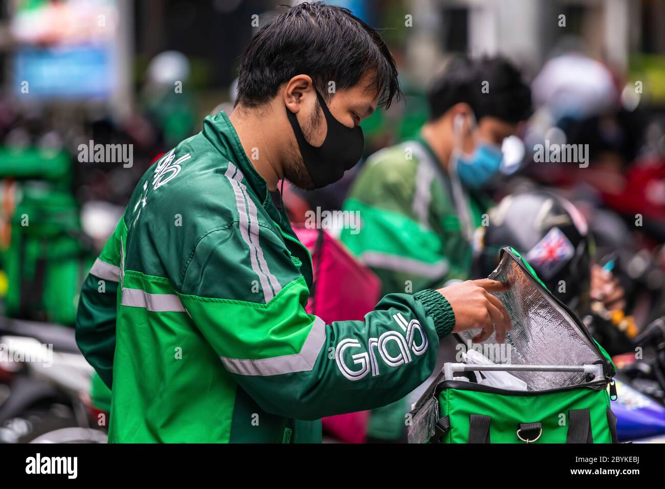 Grab motorcycle rider with face mask and mobile phone during Covid ...