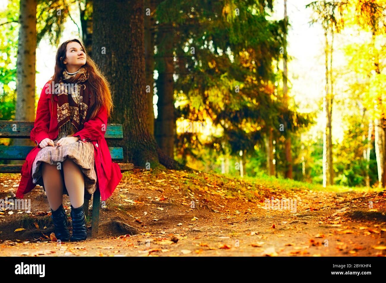 Young elegant woman sitting on bench Stock Photo - Alamy