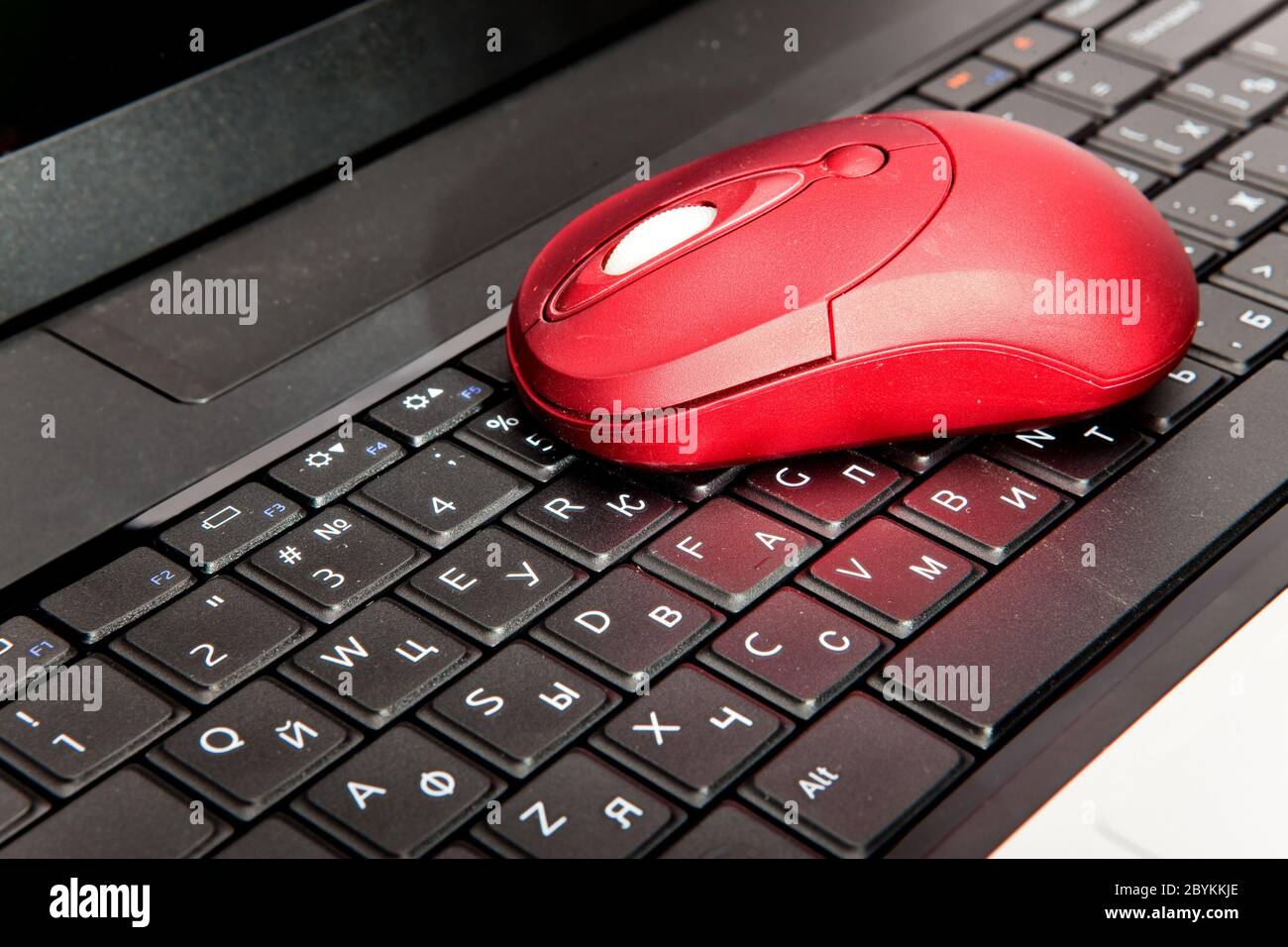 The red computer mouse on the black keyboard Stock Photo - Alamy