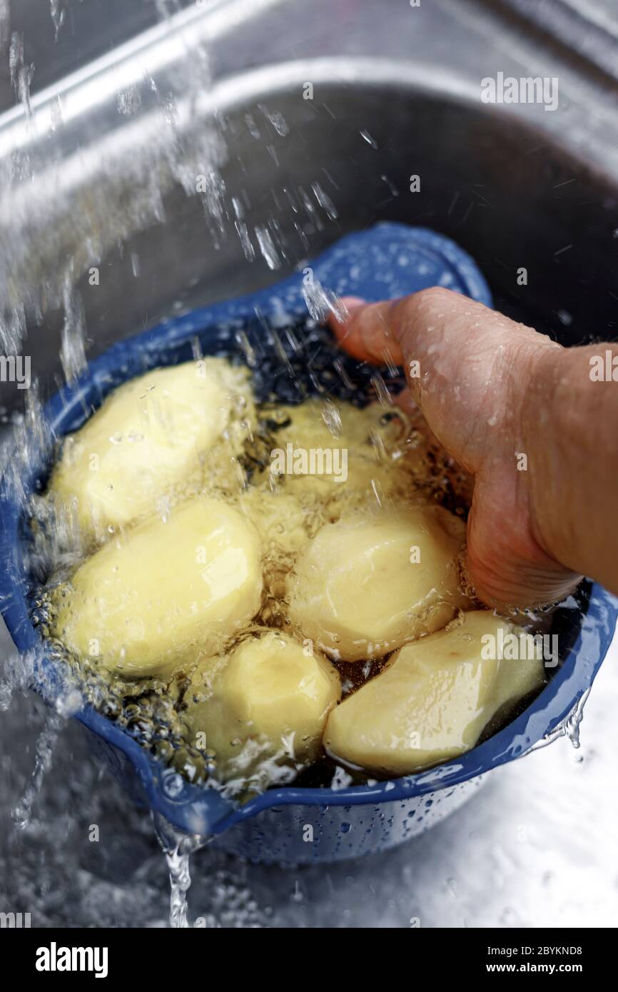 Washing potatoes under running water Stock Photo - Alamy