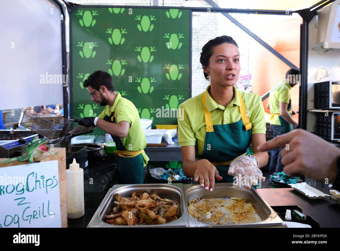 Customer finger pointing at treys with frog grill, female seller ...