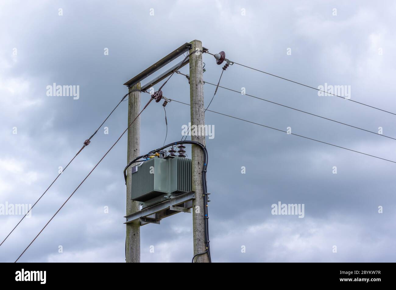 Telegraph pole style pylon with an electrical transformer with a cloudy ...