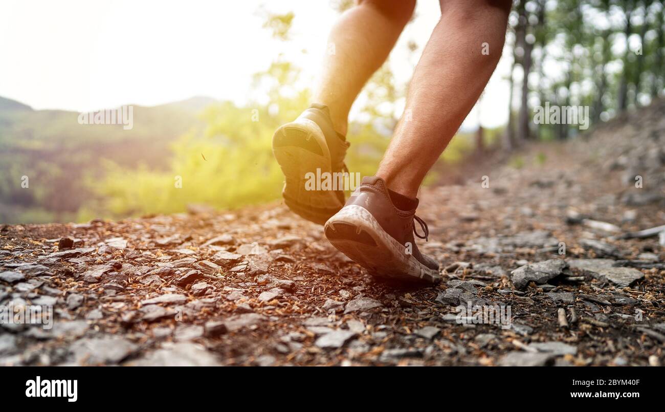 Close up male runner legs, muscular build man running fast. Trail ...