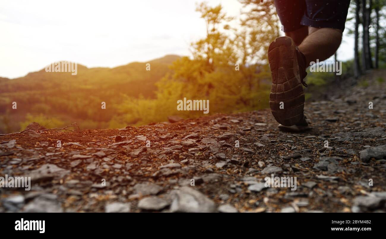 Close up male runner legs, muscular build man running fast. Trail ...