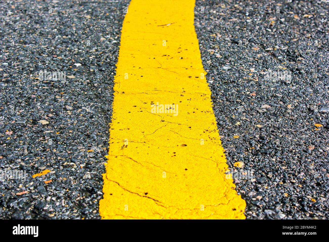 asphalt road yellow line close up background Stock Photo - Alamy