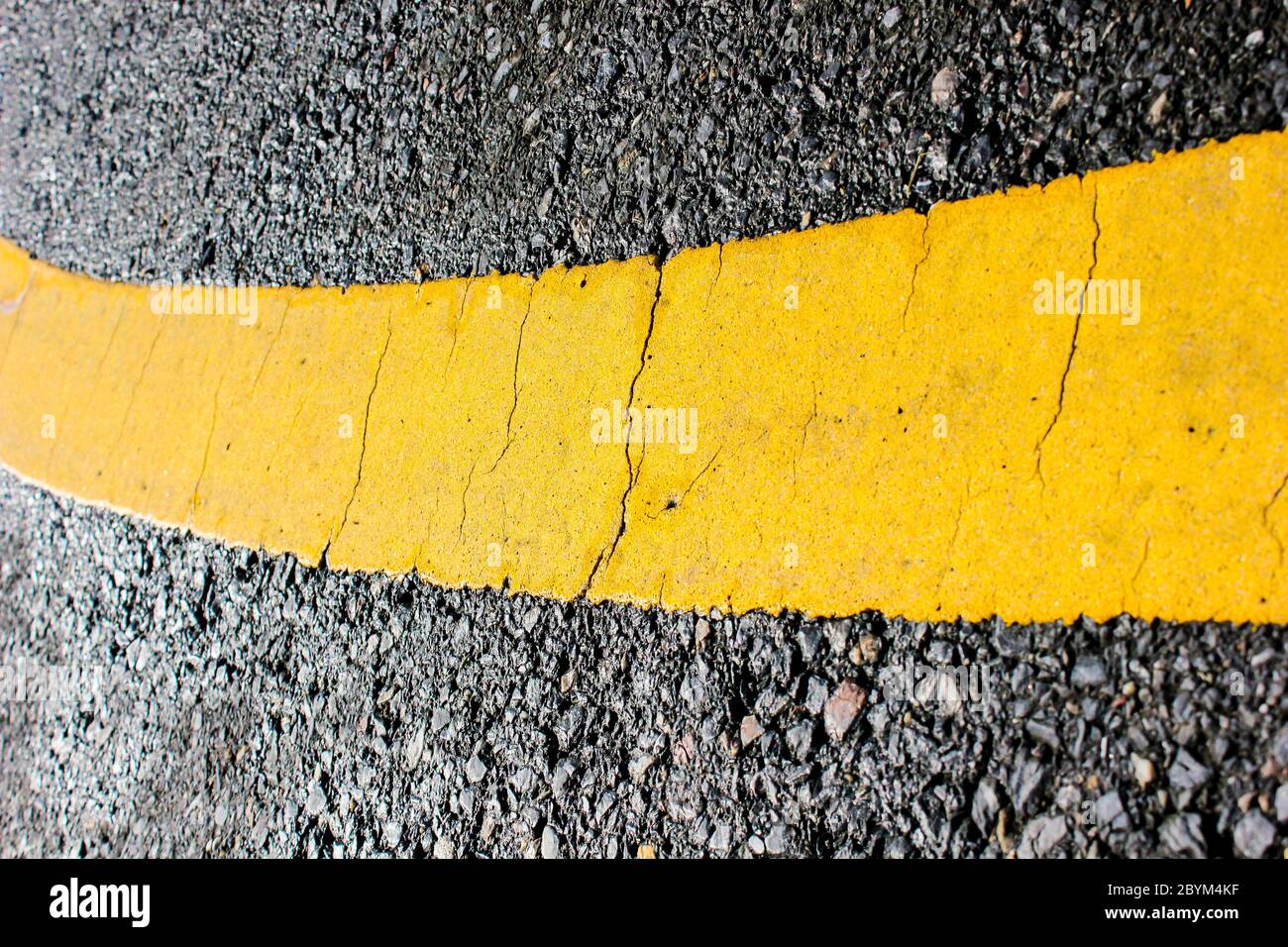 asphalt road yellow line close up background Stock Photo - Alamy