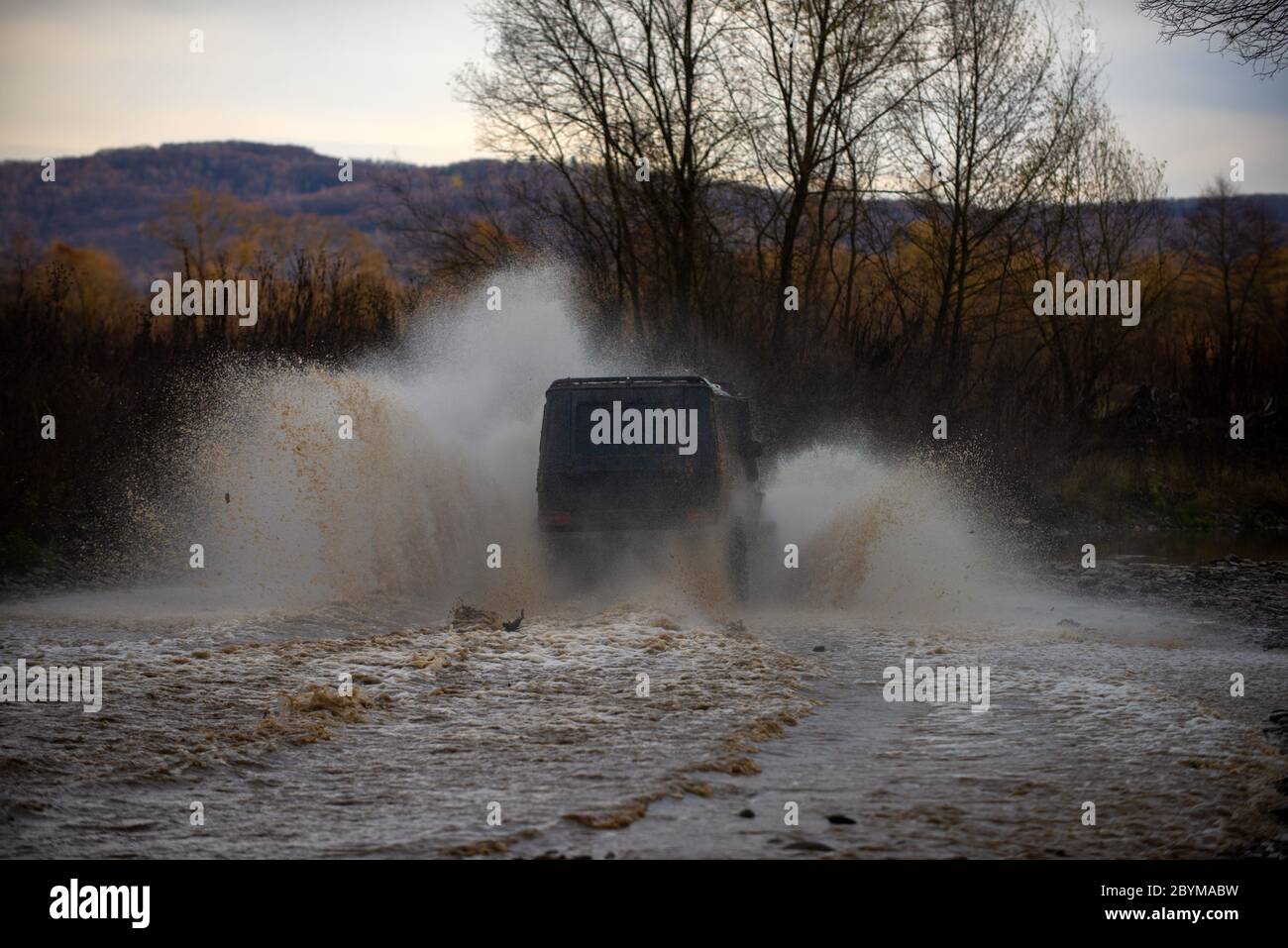 Offroad car. Offroad vehicle coming out of a mud hole hazard. Mudding ...