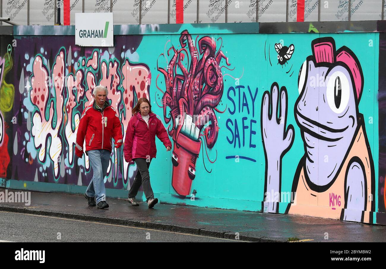 People walk passed coronavirus related graffiti hi-res stock ...