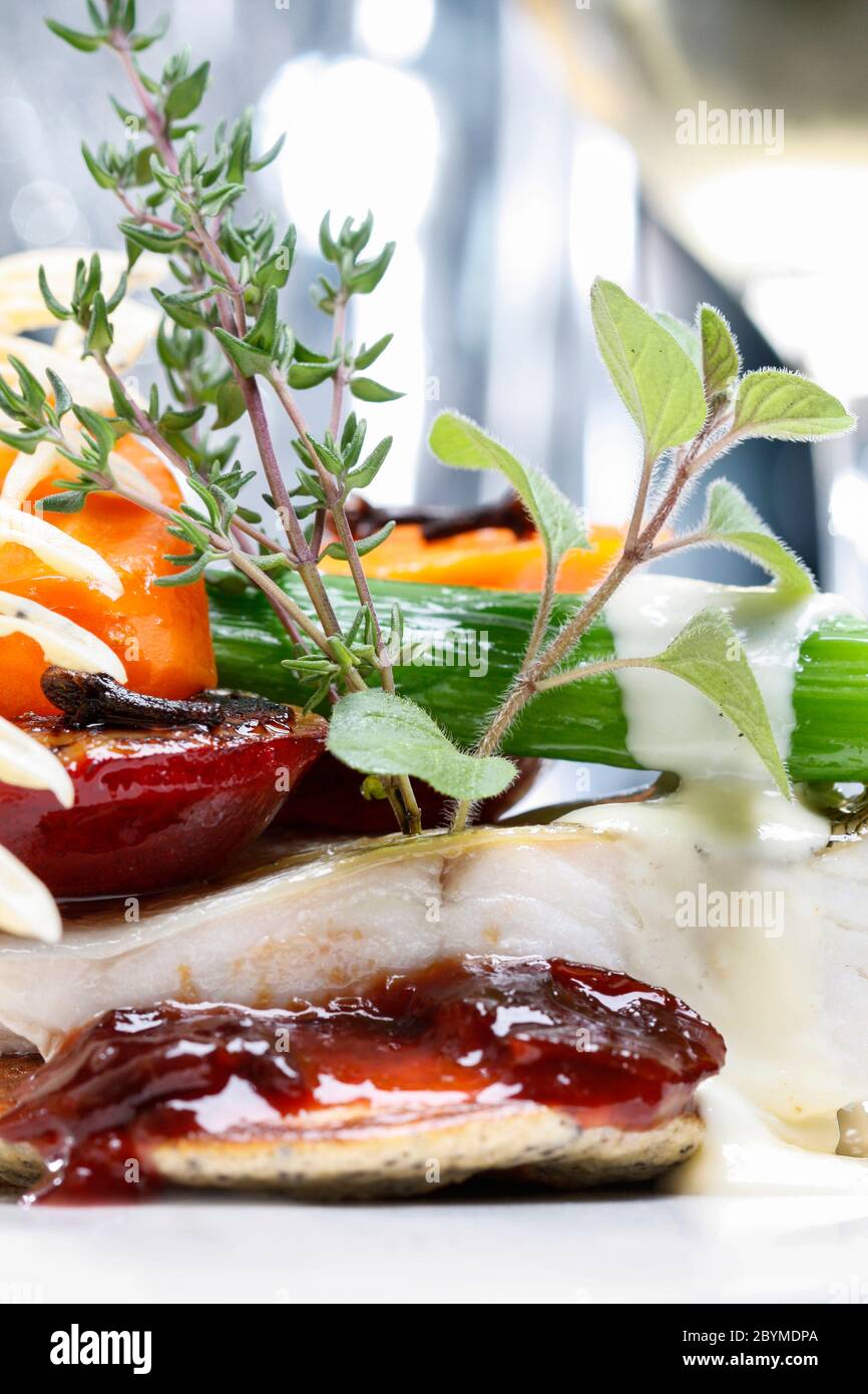 A modern dish with zander and vegetables. Table setting in luxurious ...