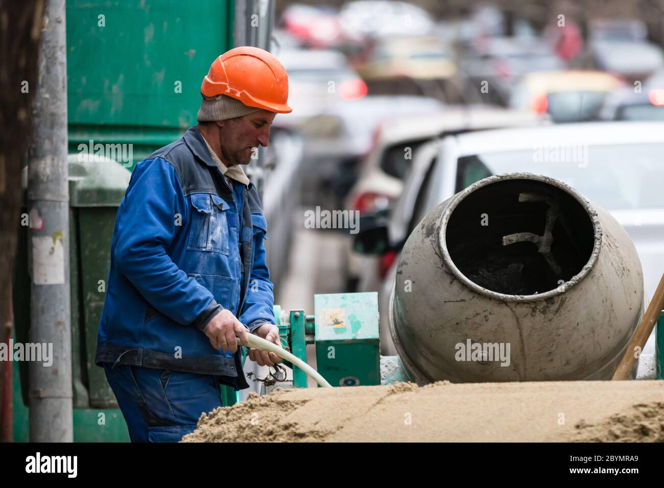 Construction wokers on building site mixing cement in Bucharest ...
