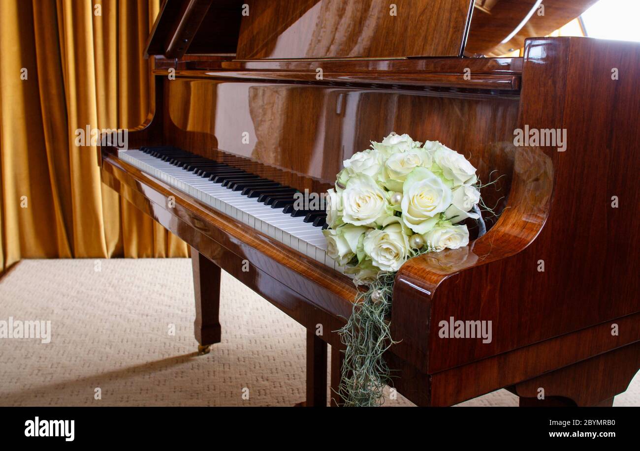 Wedding bouquet of white roses lying on the piano keys. Party decor ...
