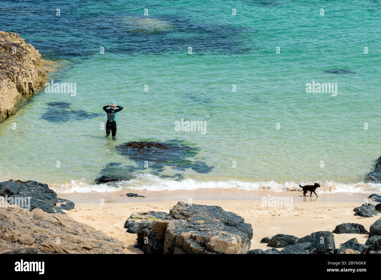 Porthgwidden Beach, Saint Ives, Cornwall, UK. A woman goes for a swim ...