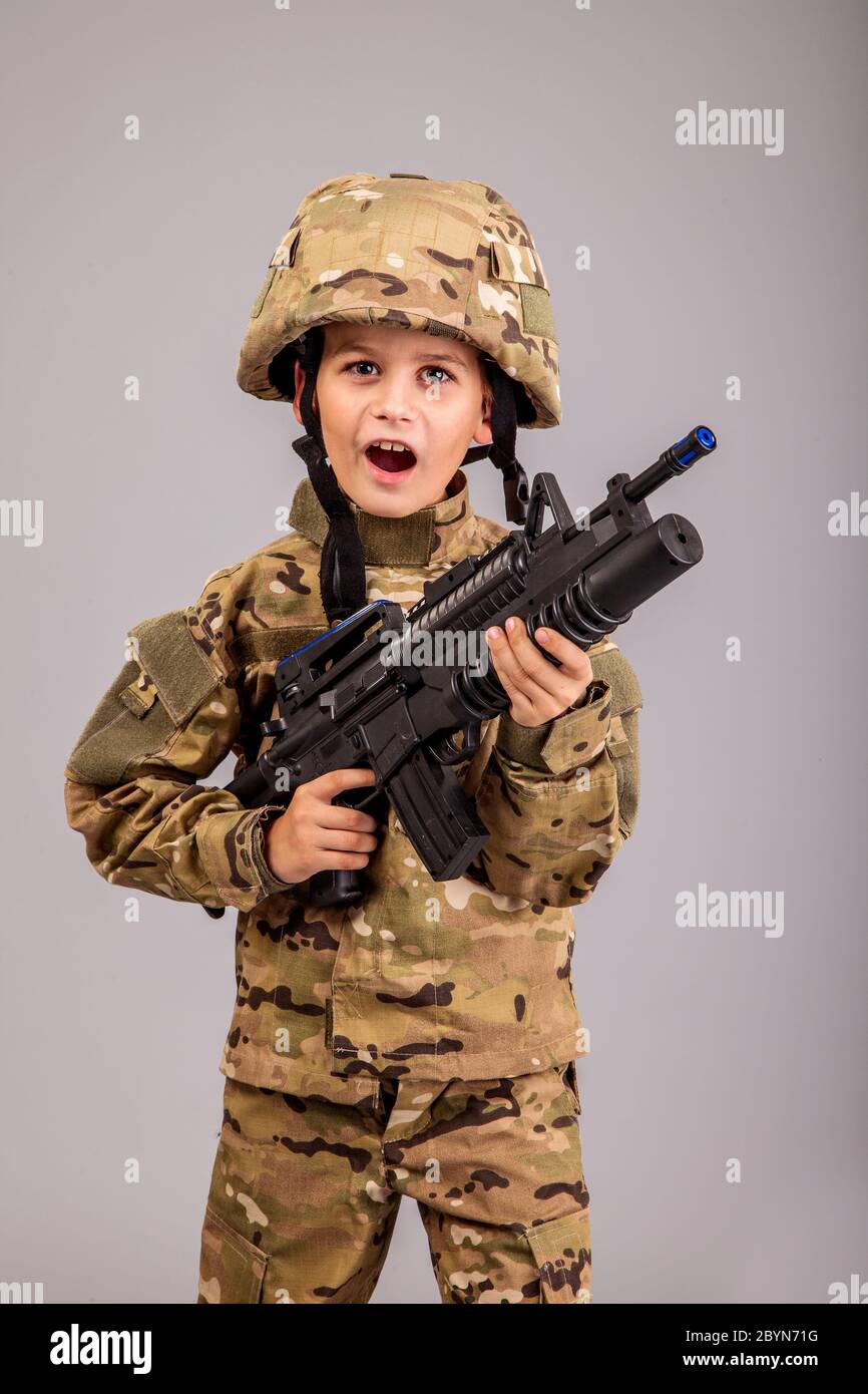 Young boy dressed like a soldier with rifle Stock Photo - Alamy