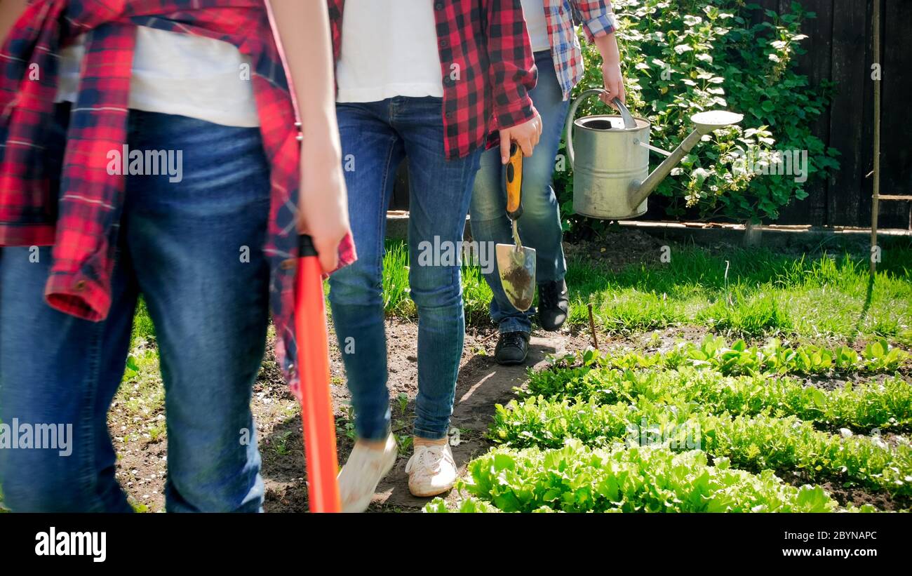Family carrying gardening tools walking in garden after hard work Stock ...