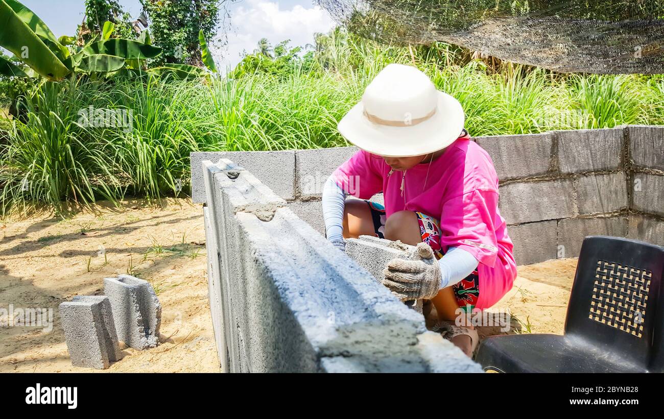 young woman masonry concrete block walls construction with cement ...