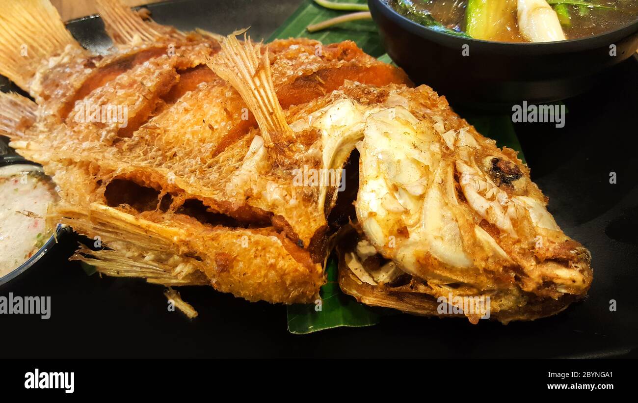 fried river fish on black dish Stock Photo - Alamy