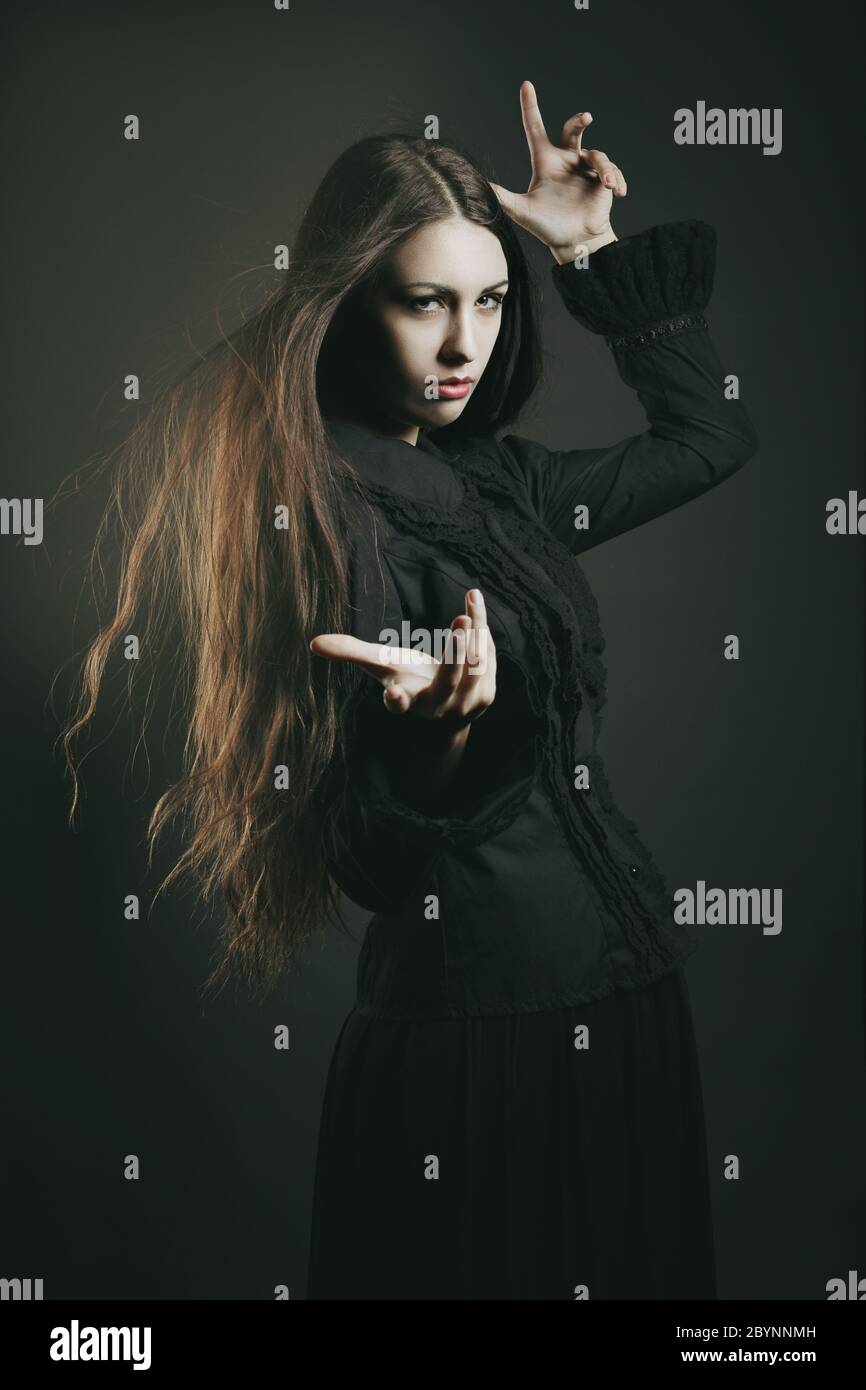 Beautiful dark witch casting a spell . Halloween and fantasy studio ...