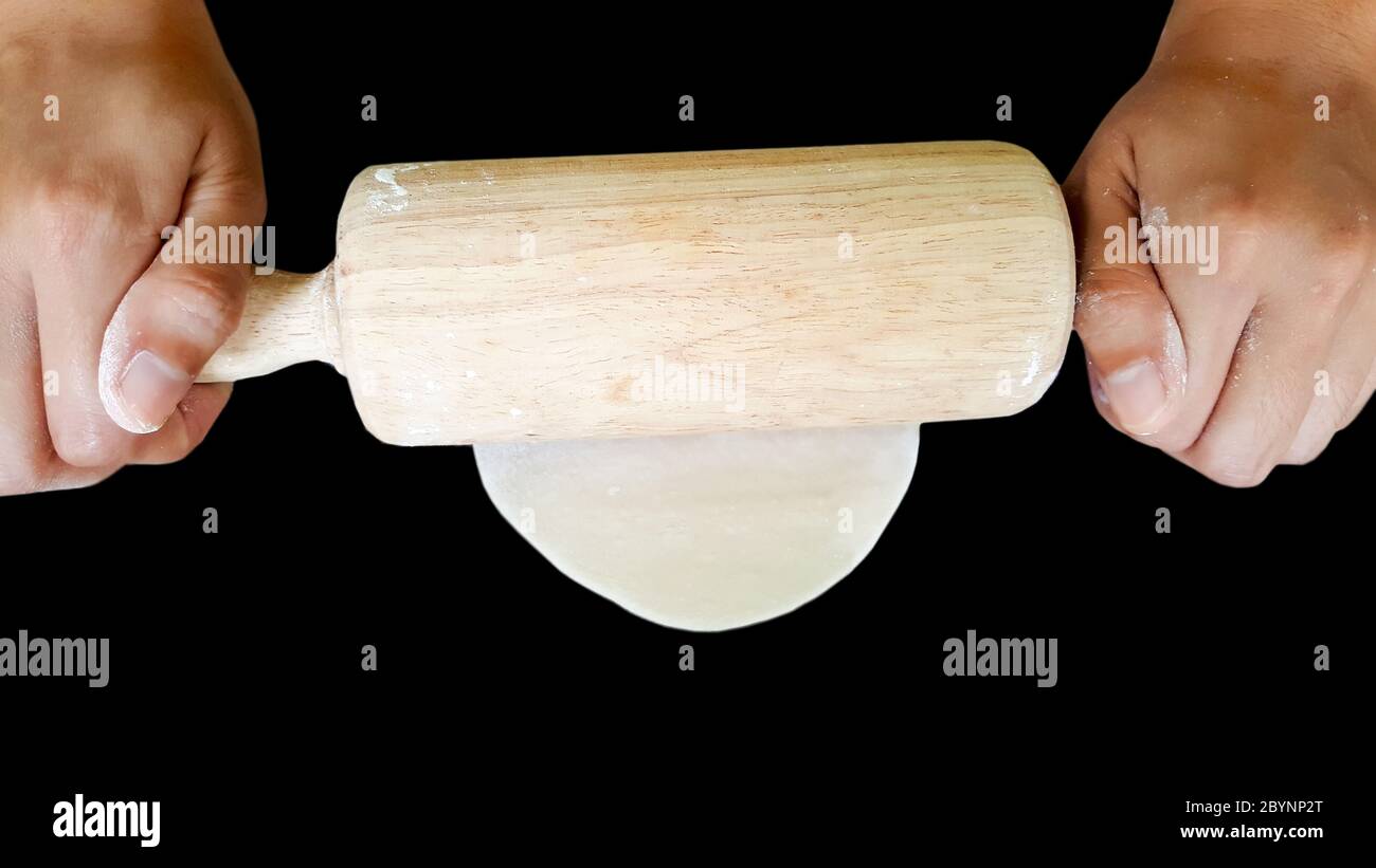 close-up hands thresh flour with wooden rolling isolated on background ...