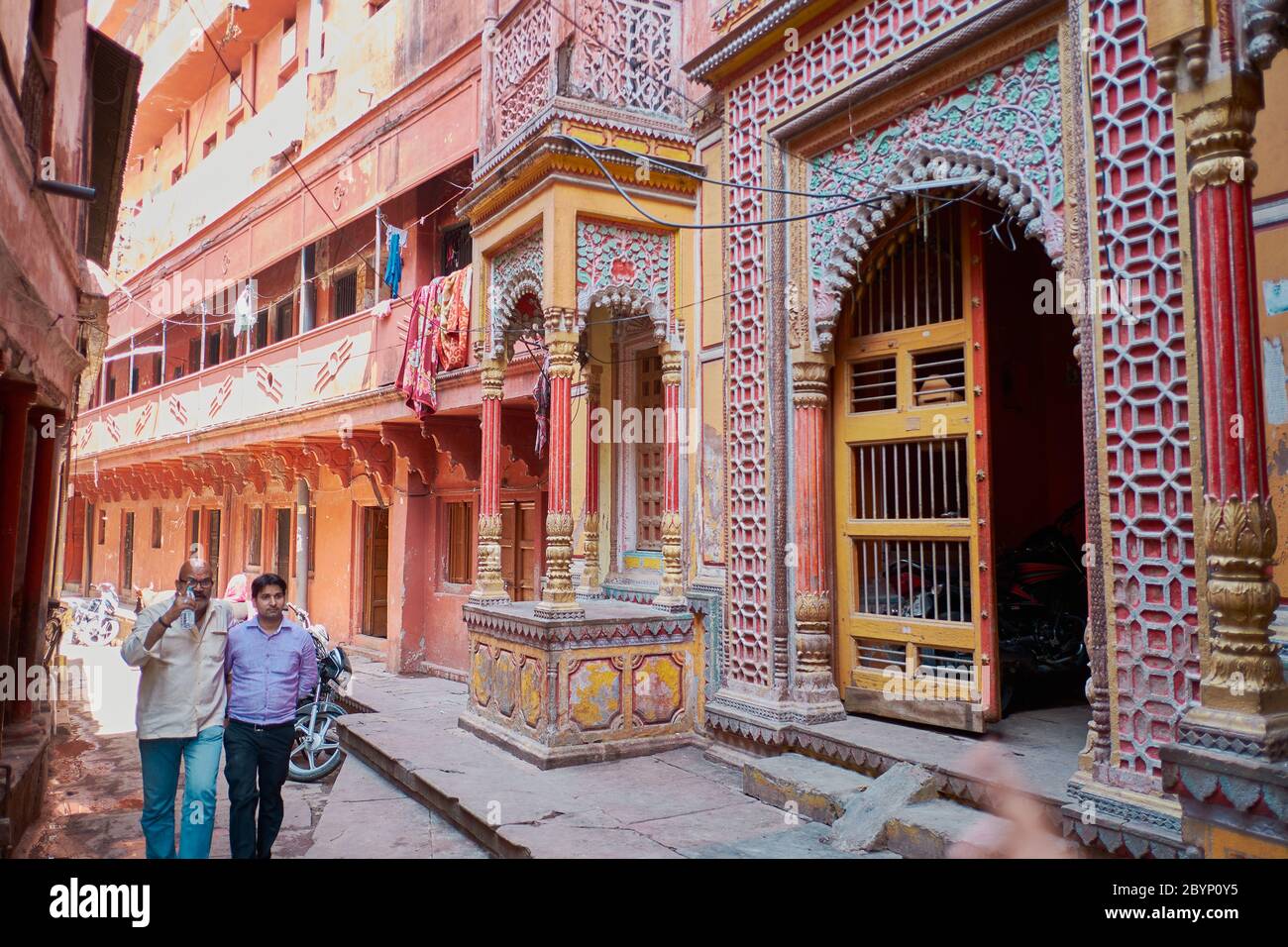 Two men crossing an old traditional Indian wrestling academy next to ...