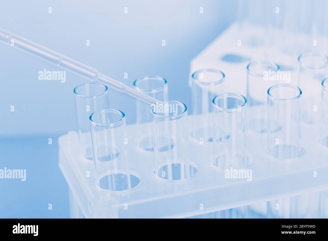 Laboratory glassware with a dropper dripping liquid into a test tube ...