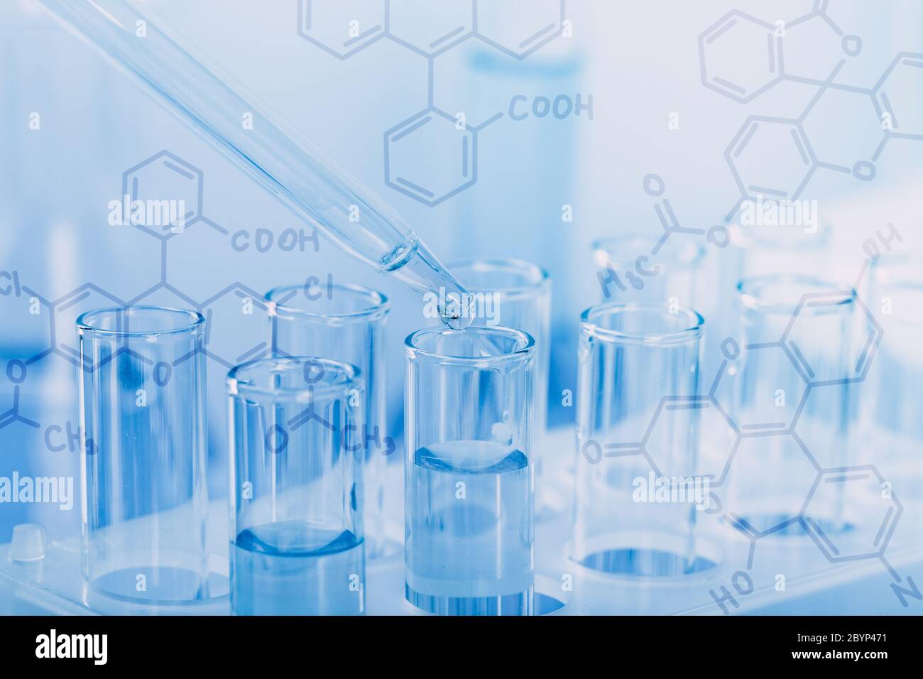 Laboratory glassware with a dropper dripping liquid into a test tube ...