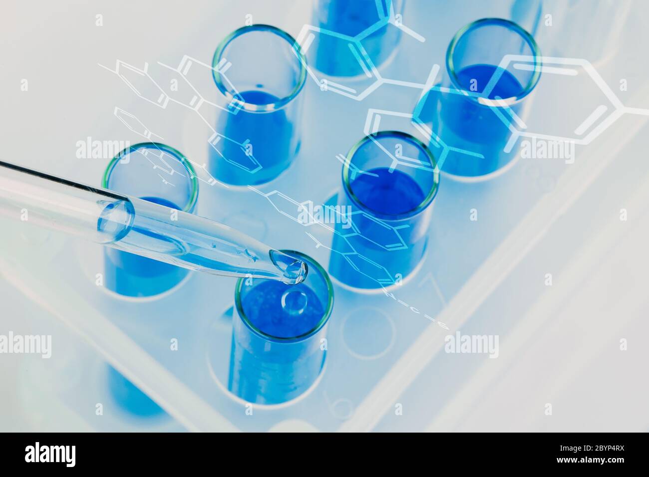 Laboratory glassware with a dropper dripping liquid into a test tube ...