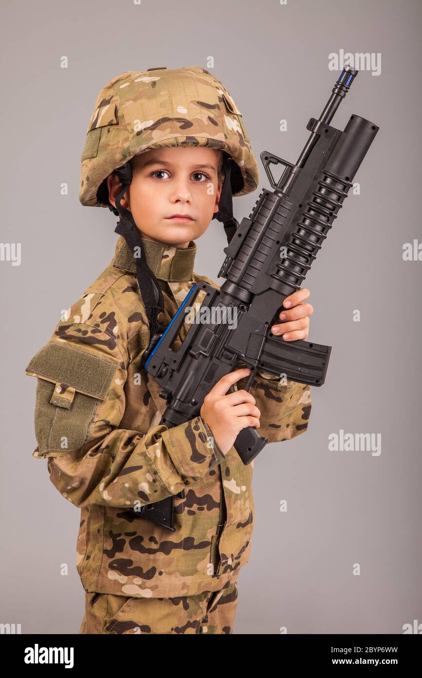 Young boy dressed like a soldier with rifle Stock Photo - Alamy