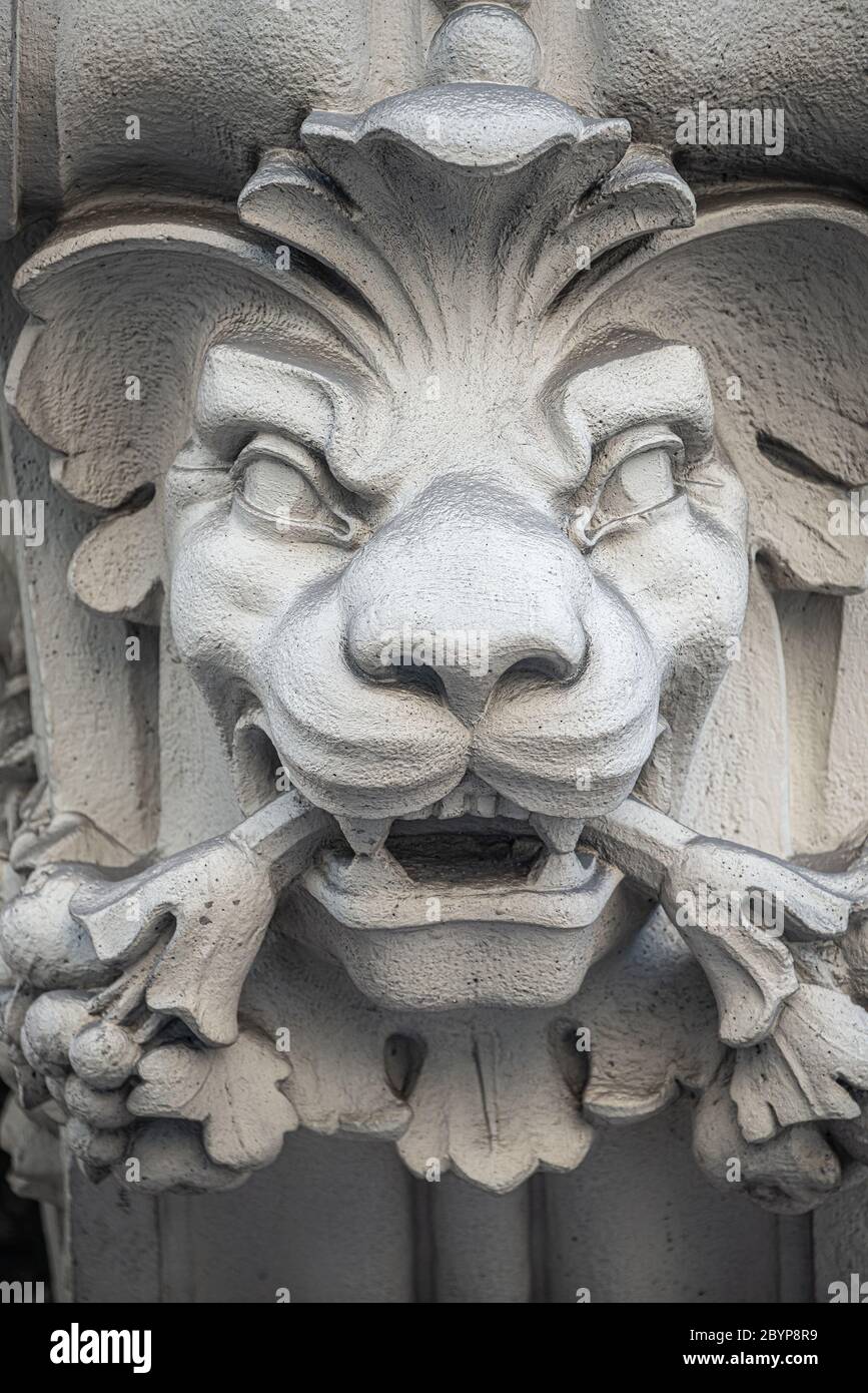 Statue of powerful and emotional head of a lion as support for building ...