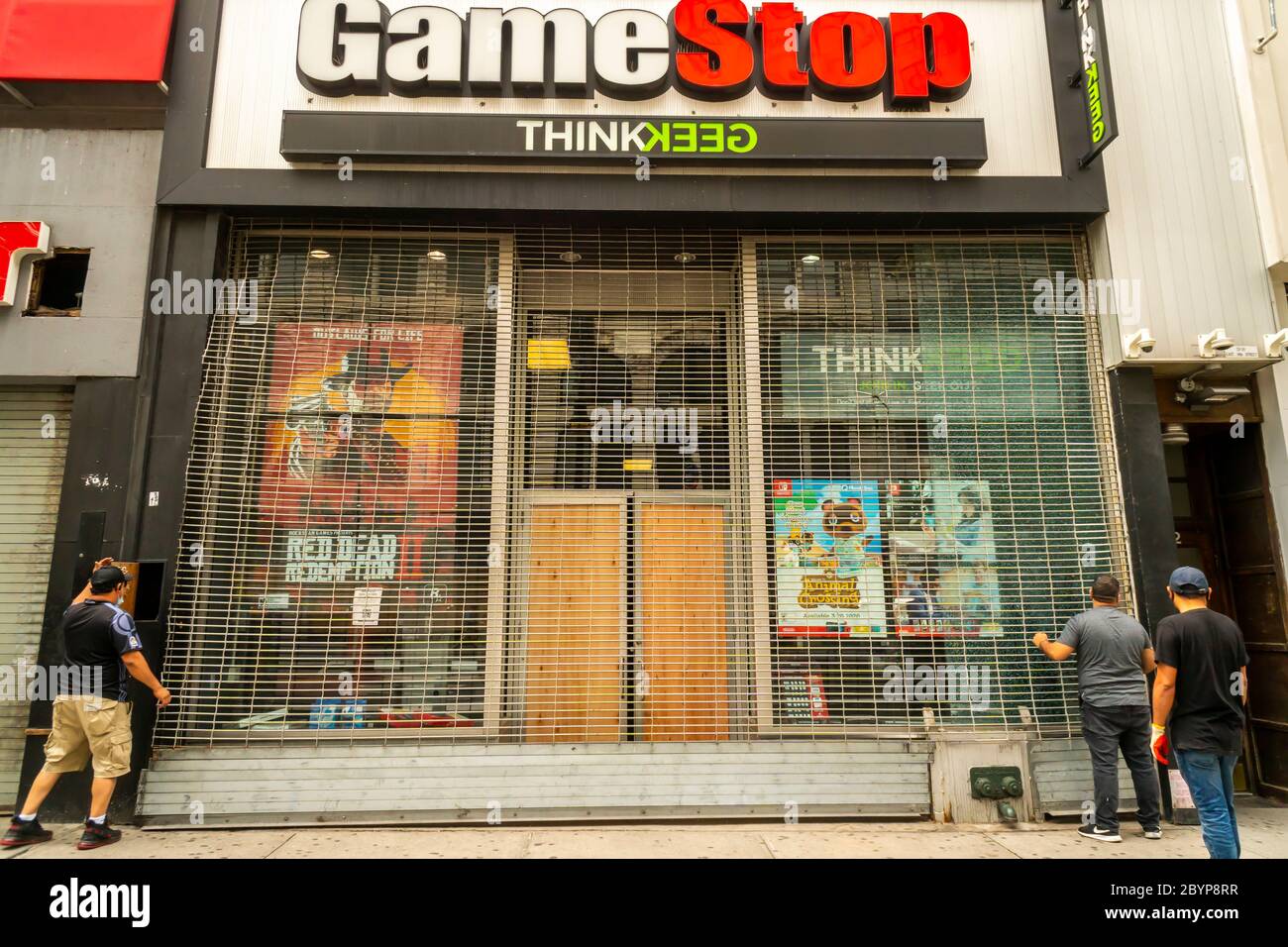Workers repair a roll down gate of a GameStop in Union Square in New ...