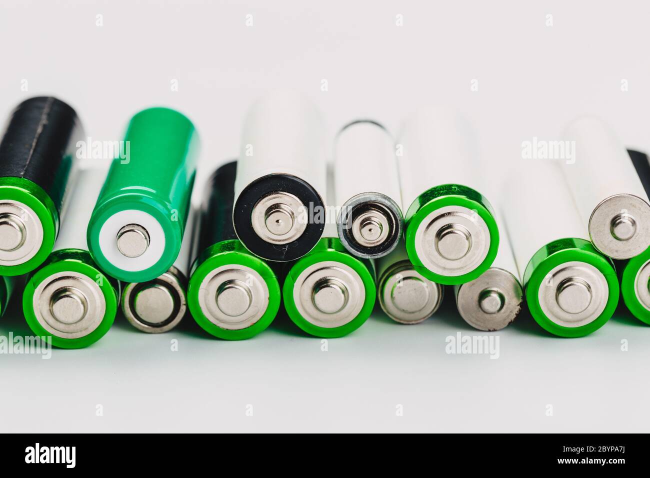 many new and used alkaline batteries type AA on a light background ...