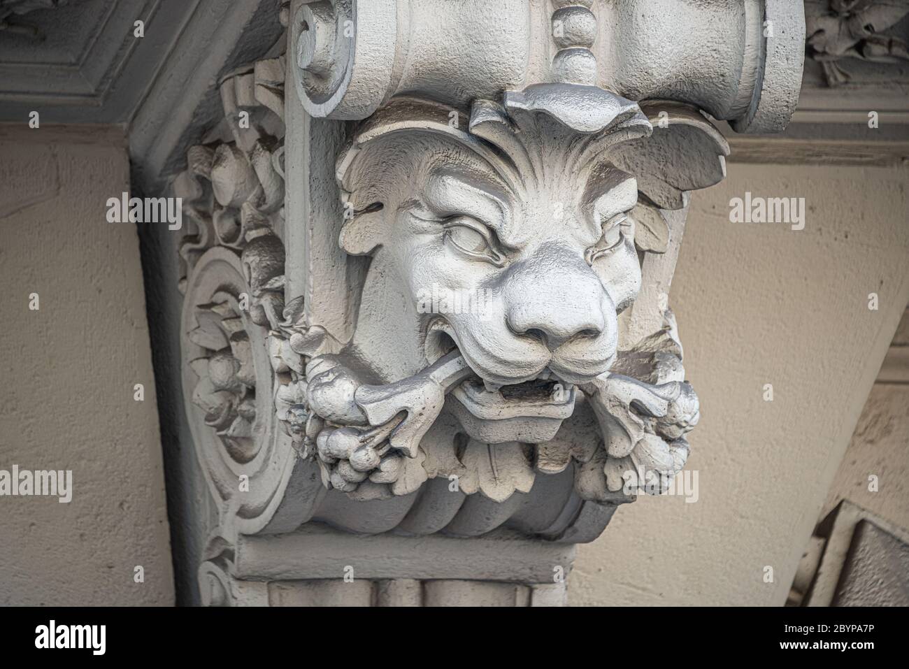 Statue of powerful and emotional head of a lion as support for building ...