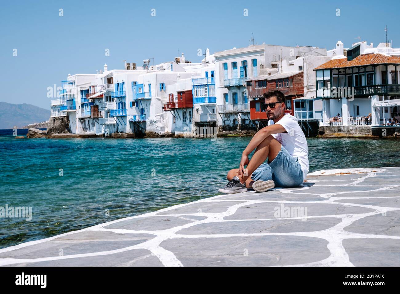 young guy on vacation at the Greek Island of Mykonos, men relaxing at ...