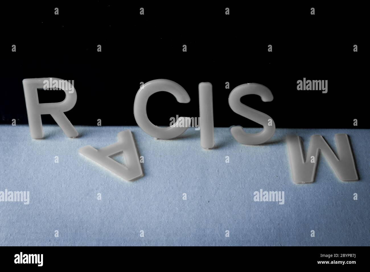 Drop racism, word written with letters on a two-tone background, the ...