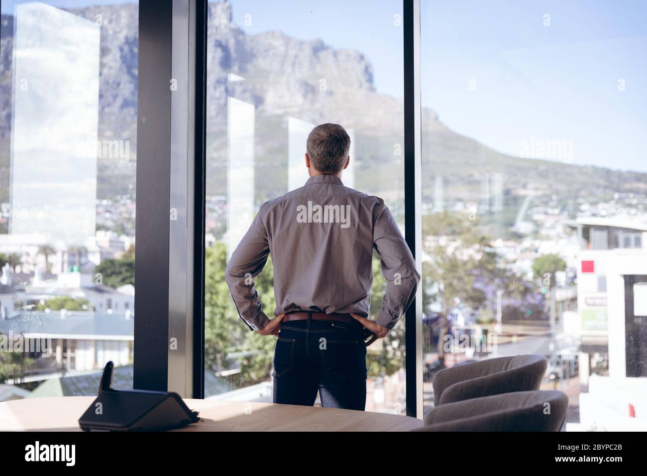 Caucasian business man standing in front of windows Stock Photo - Alamy