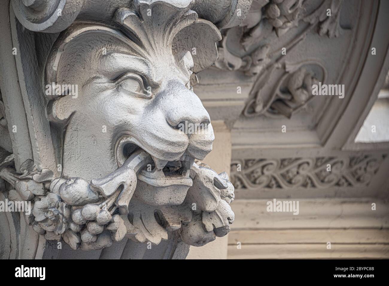 Statue of powerful and emotional head of a lion as support for building ...