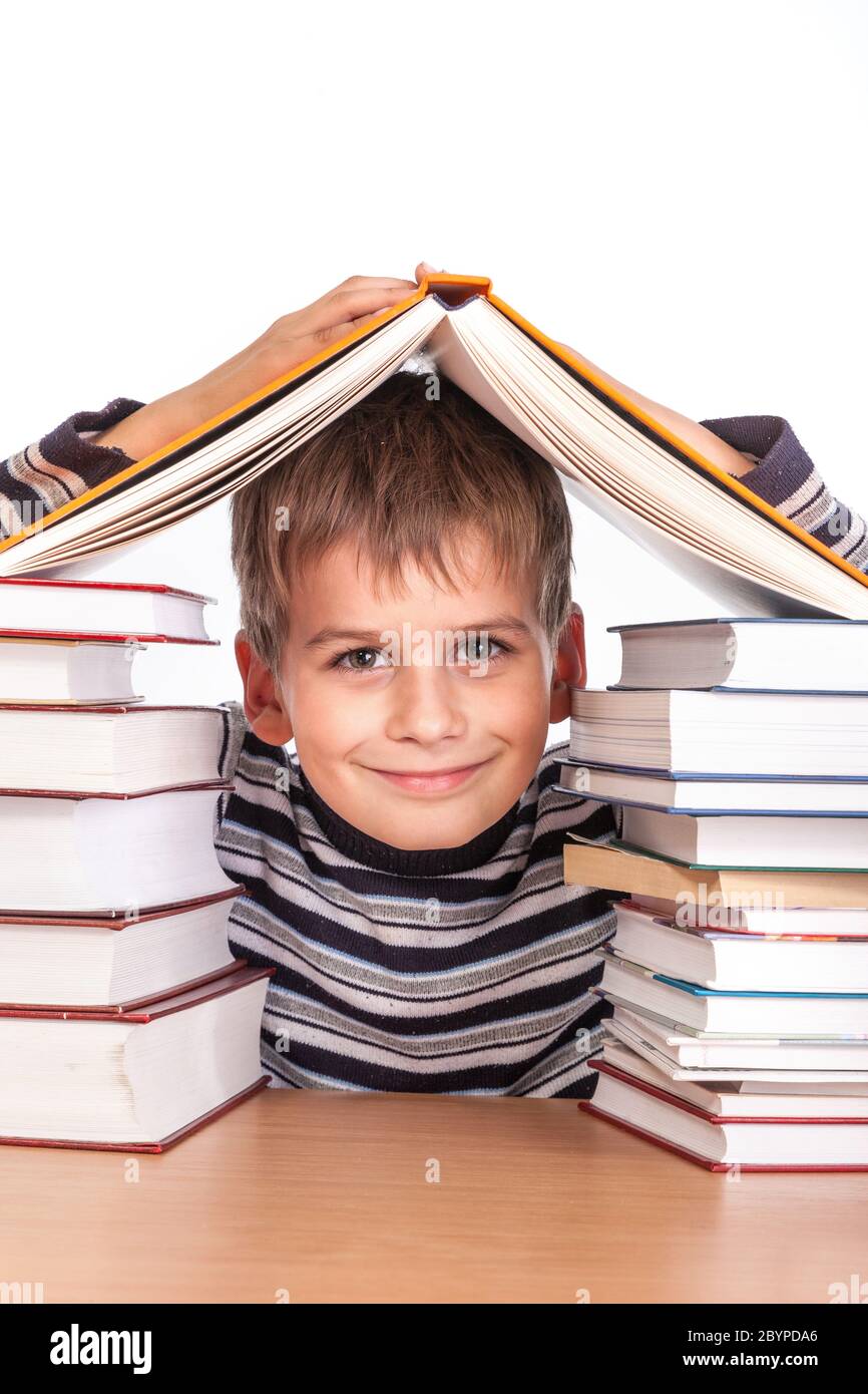Schoolboy and a heap of books Stock Photo - Alamy